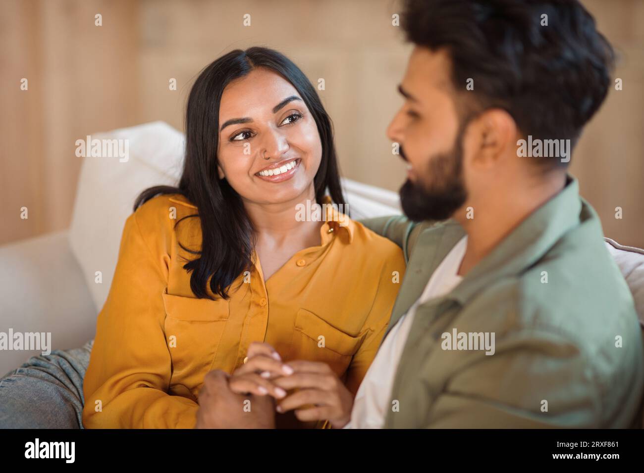 Loving indian couple holding hands and talking, enjoying pleasant ...