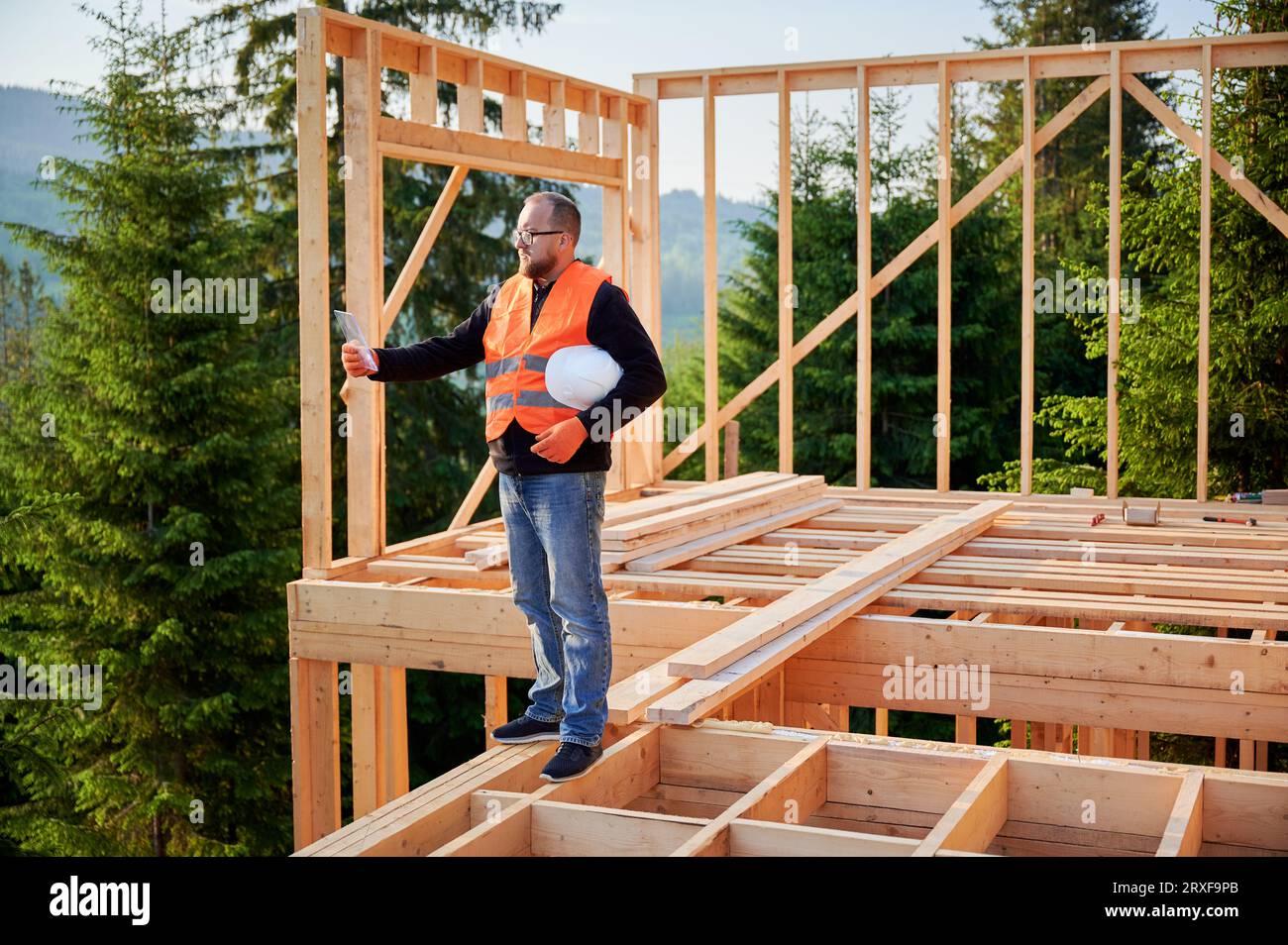 Manager overseeing construction of wooden two-story house located close ...