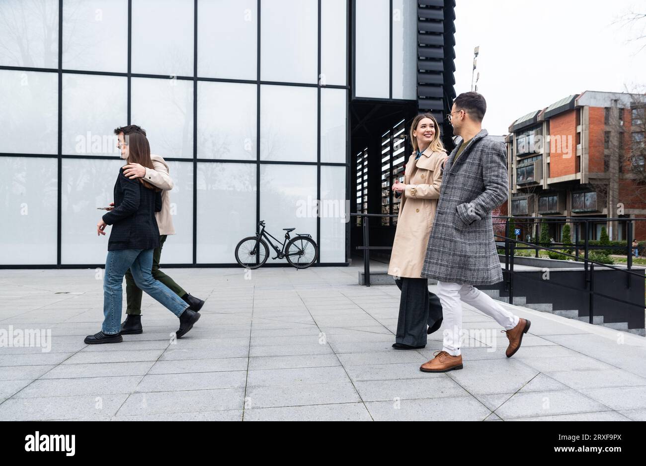Group of business people walking outside in front of office building ...
