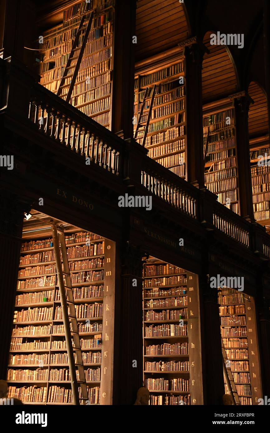 Old books on the shelves inside the Old library in Trinity College ...