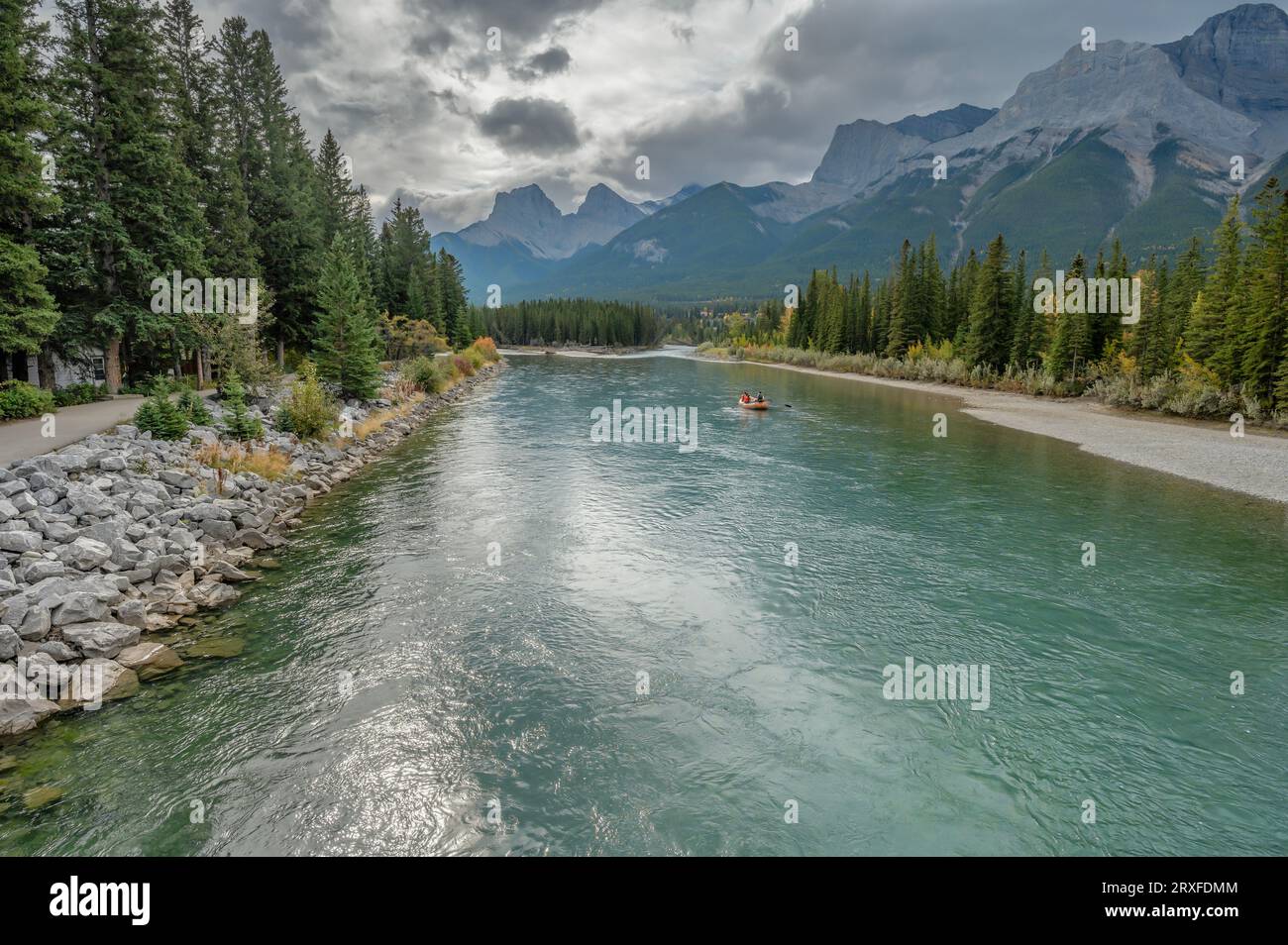 A single raft floats down the Bow River in the town of Canmore, Alberta ...