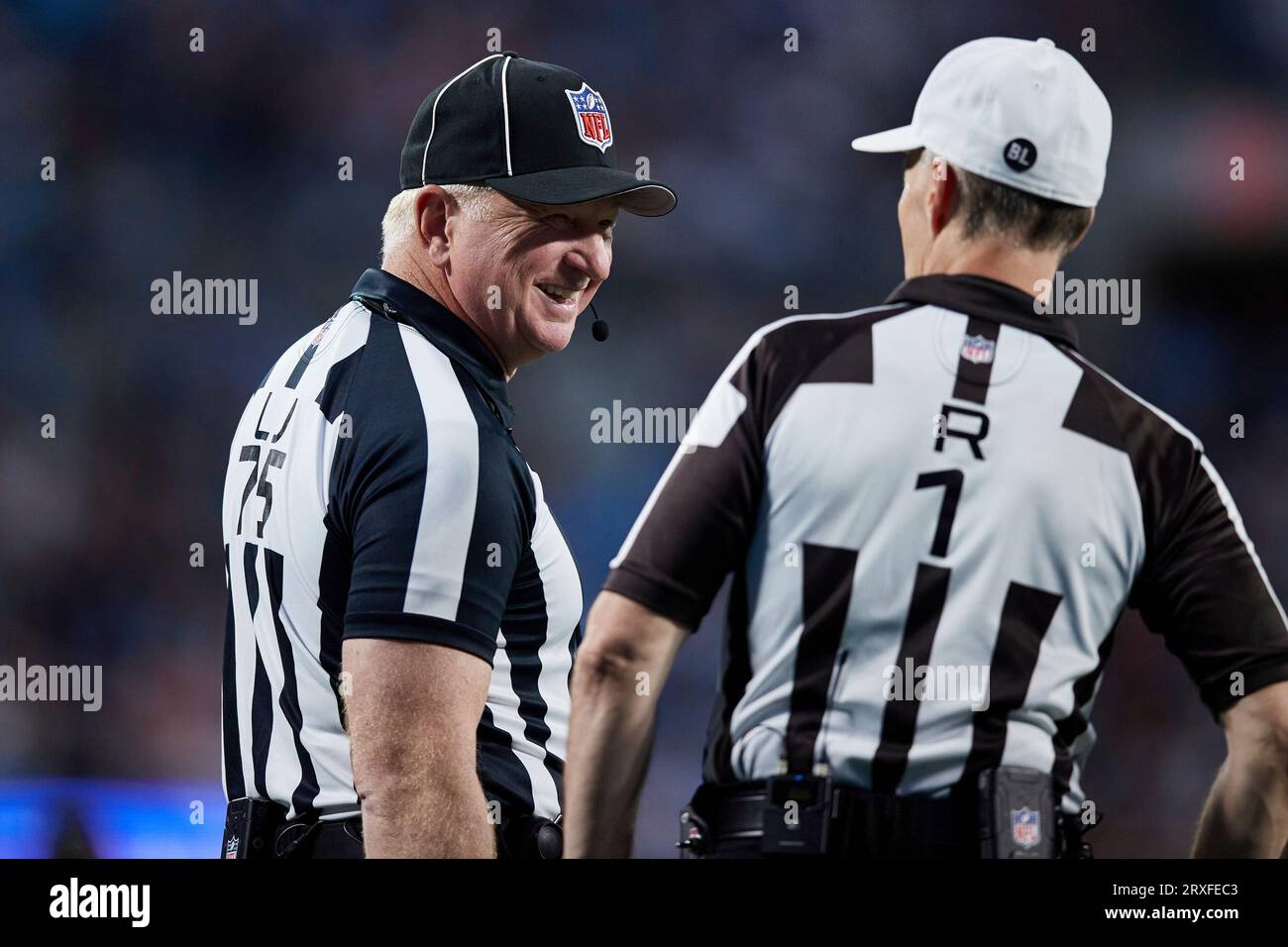 Line judge Mark Stewart (75) smiles as he chats with referee Scott ...