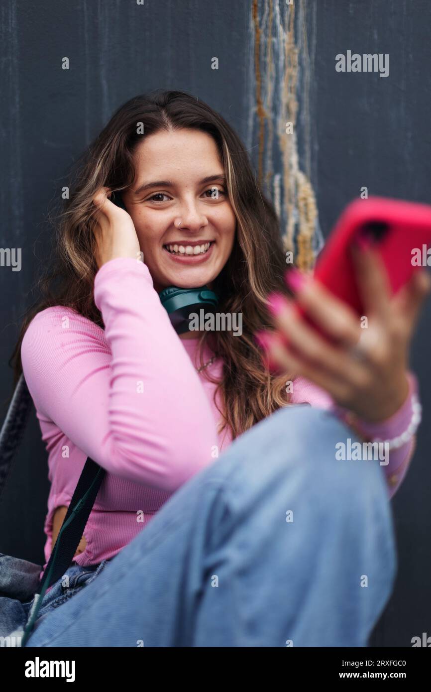 Portrait of generation z girl student sitting outdoors in the city ...