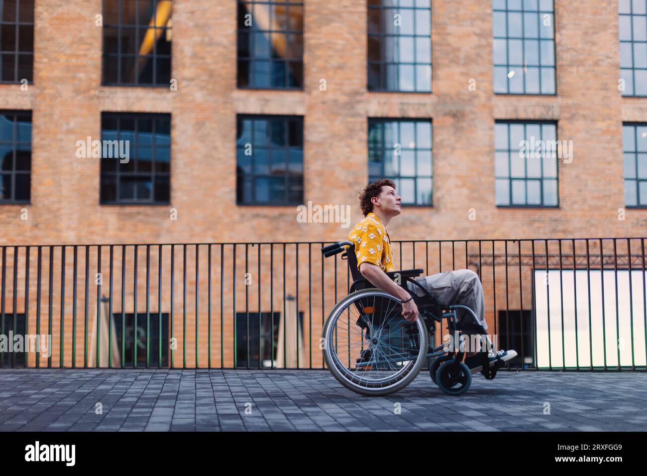 Gen Z boy in a wheelchair in the city Stock Photo - Alamy