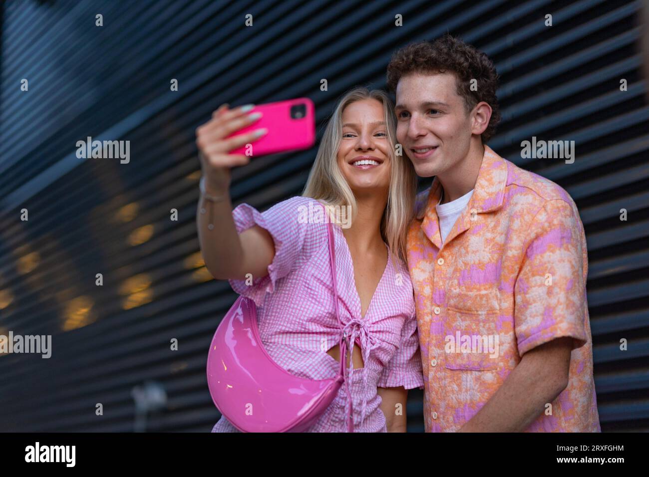 Gen Z couple in pink outfit taking selfie before going the cinema to ...