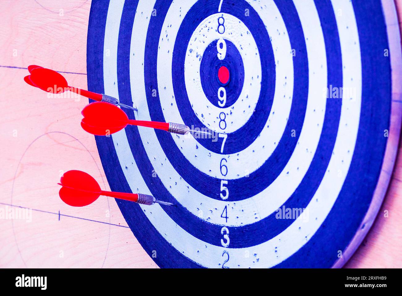 Targets for archery on a green background. Three red darts in the ...
