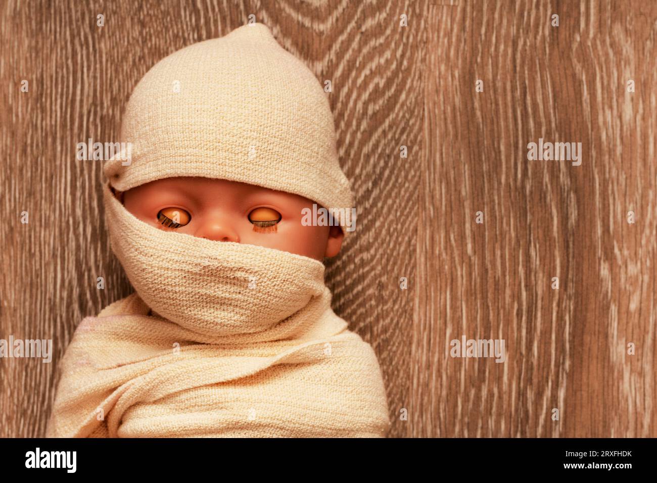 The doll the baby is wound with fabric. The body of the child is ...