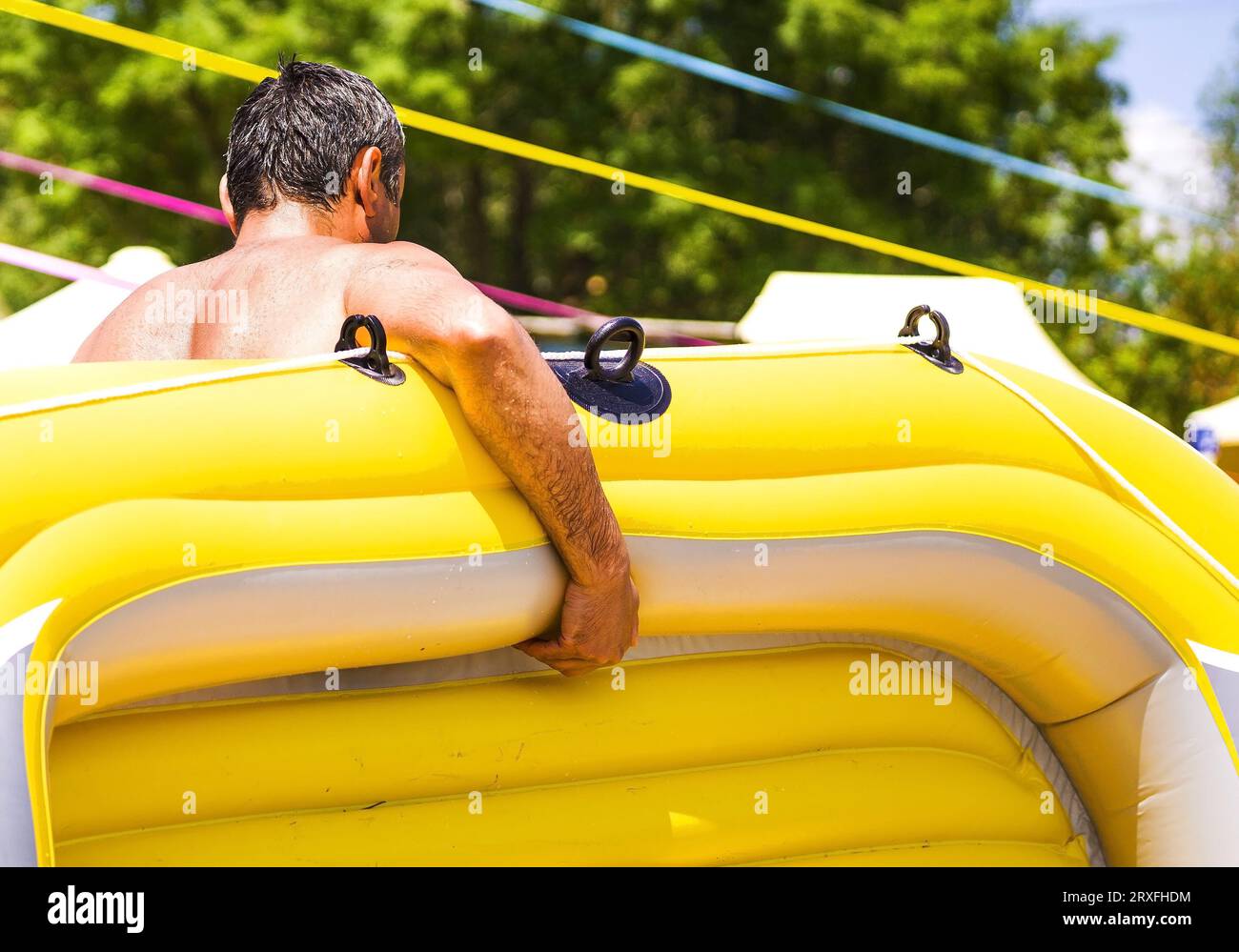 The man on the beach with the inflatable rubber boat. male carries the ...