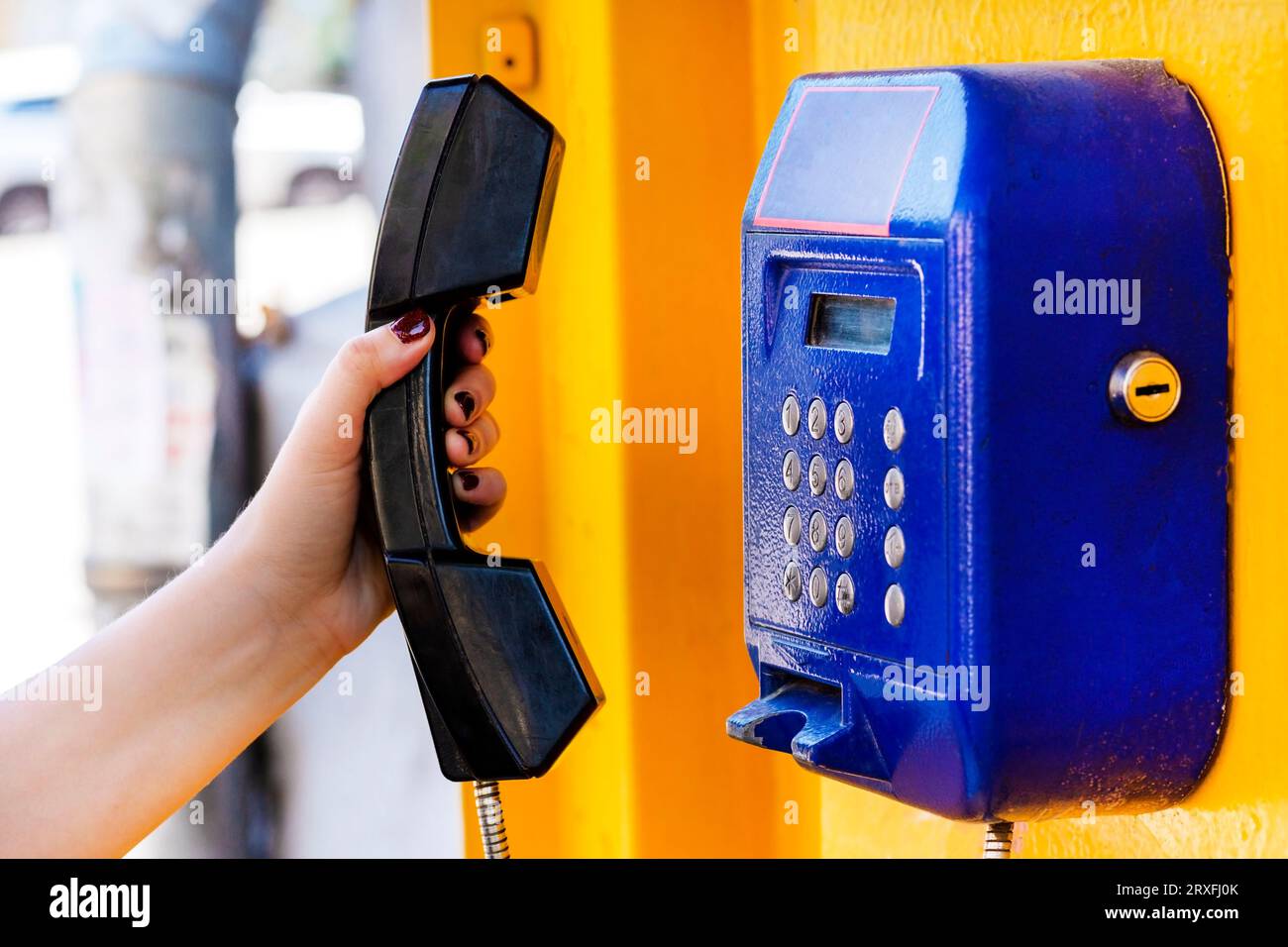The hand holds a payphone tube. Close-up. Dialing a number with hand ...