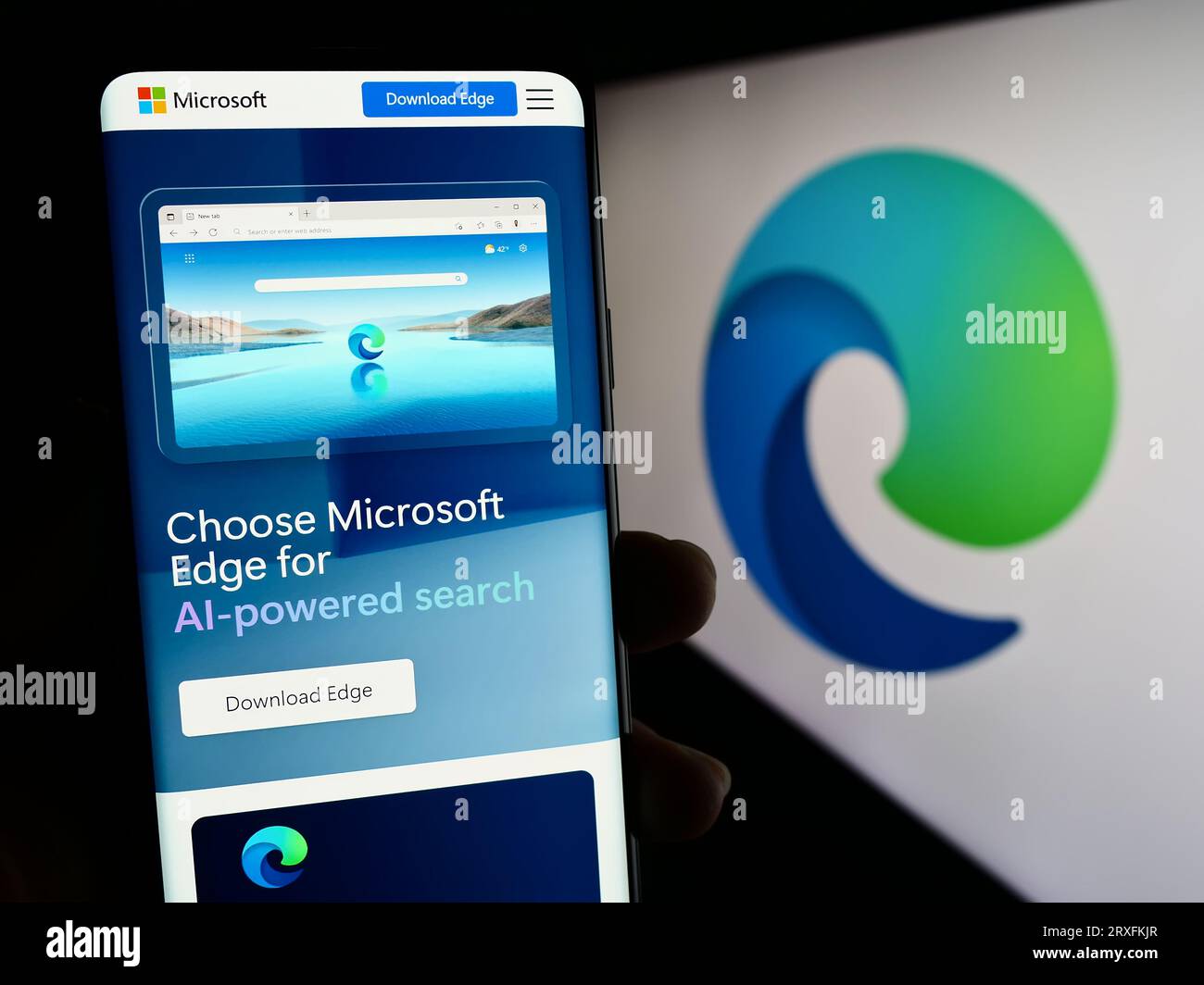Person holding mobile phone with web page of web browser Microsoft Edge on screen in front of ...