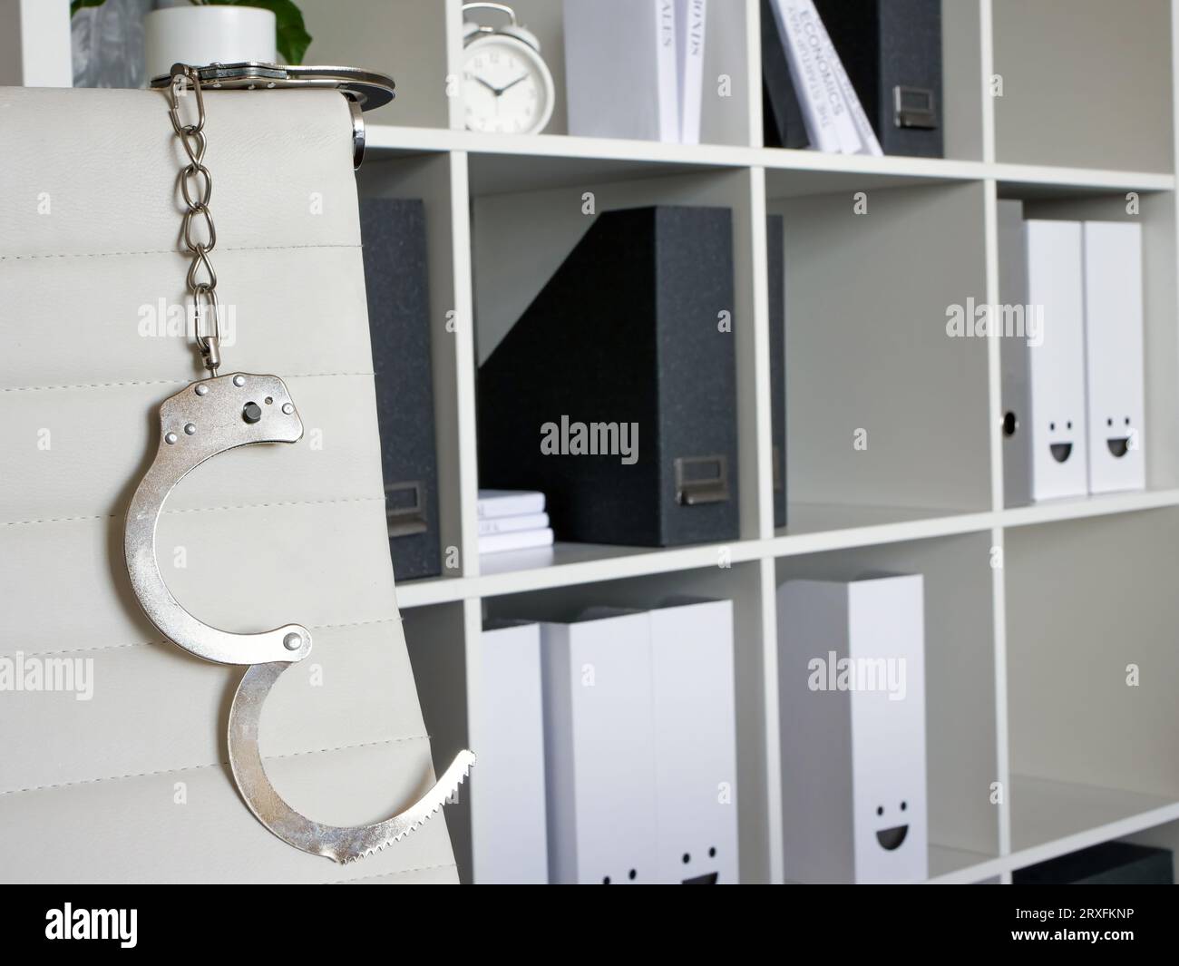 Handcuffs on the back of an office chair as concept for financial crime ...