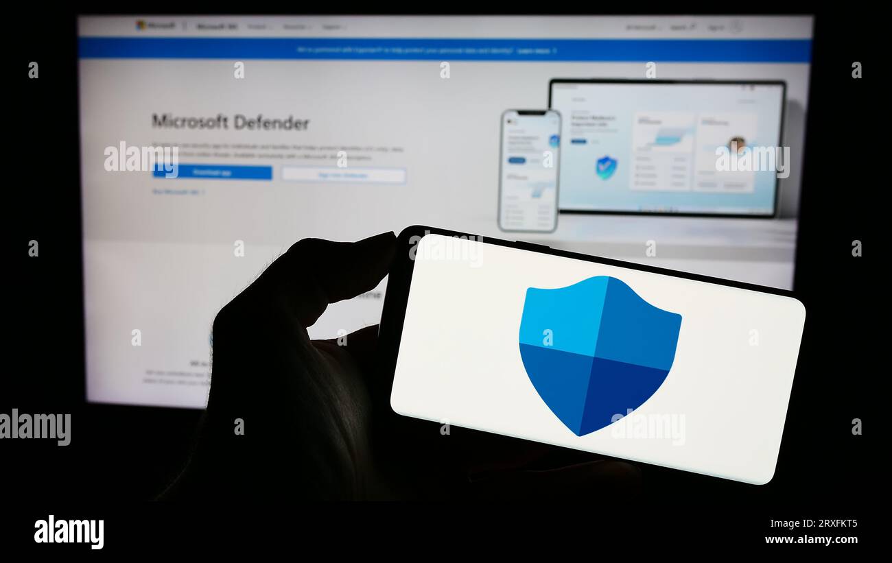 Person holding mobile phone with logo of security software Microsoft ...