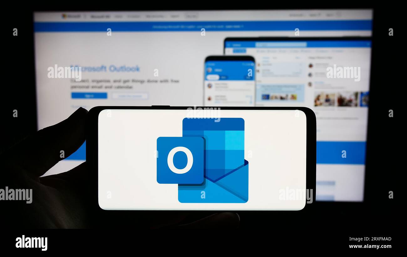Person holding smartphone with logo of email software Microsoft Outlook ...