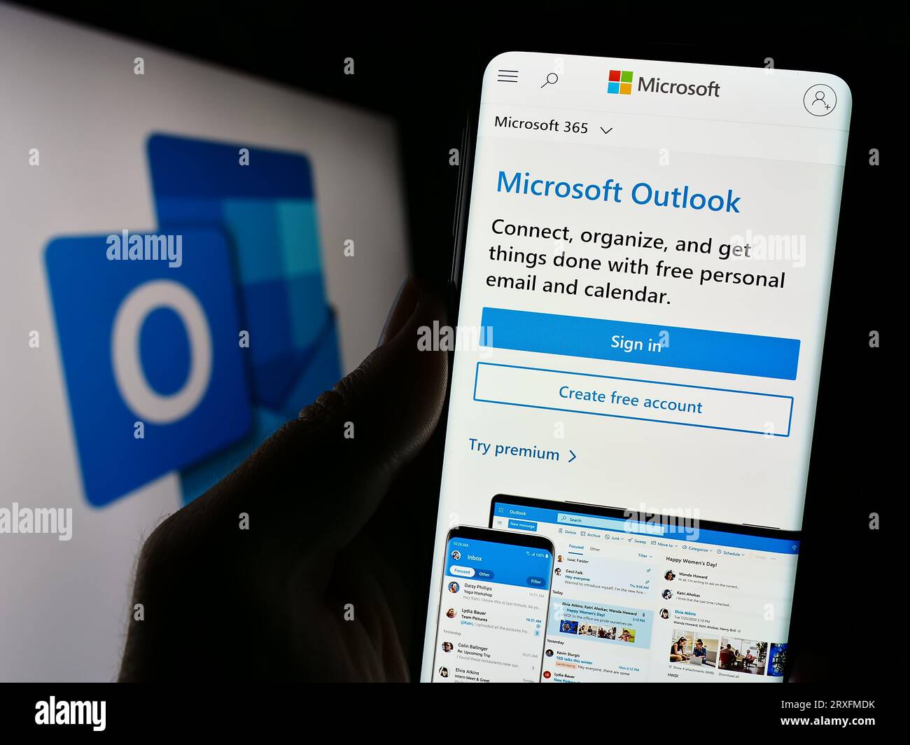 Person holding cellphone with webpage of email software Microsoft ...
