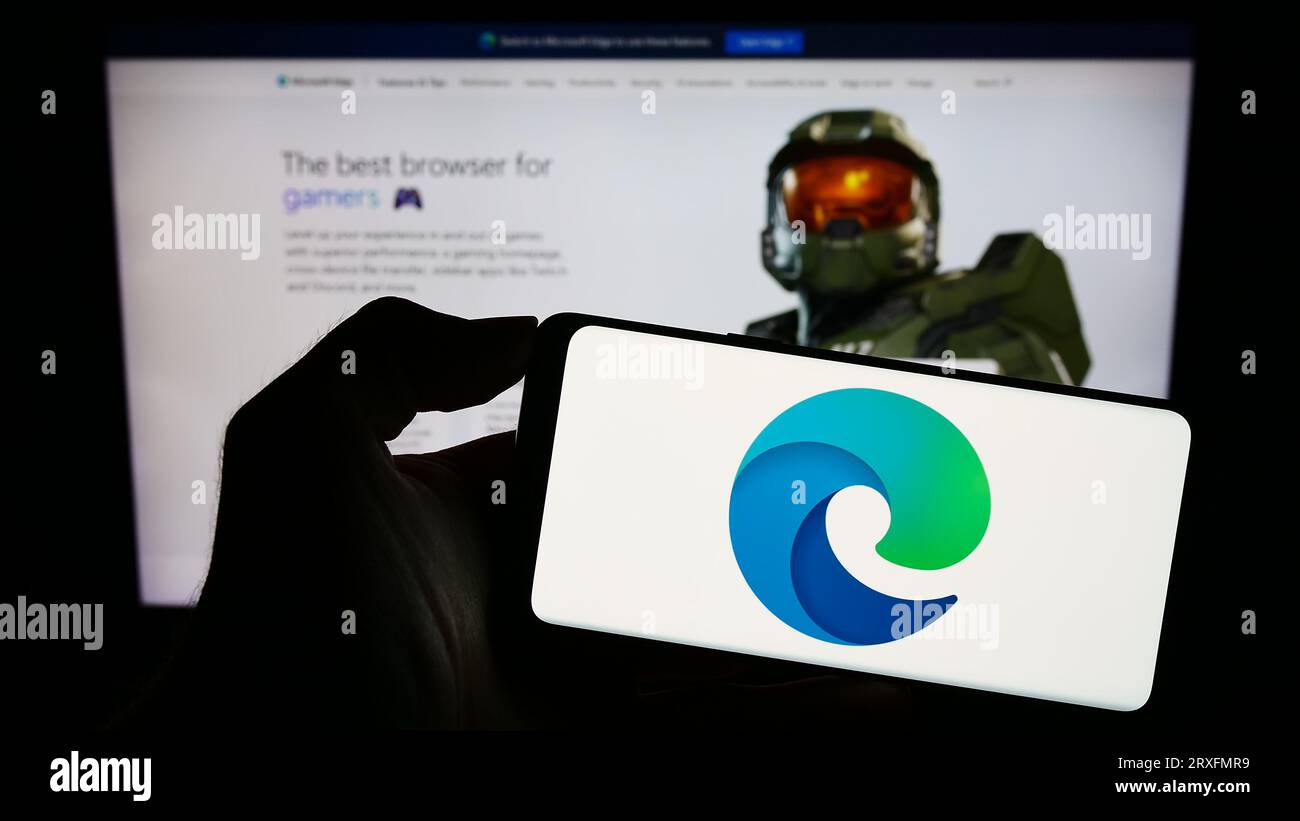 Person holding mobile phone with logo of web browser Microsoft Edge on ...