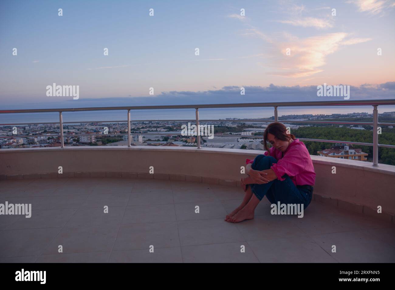 Beautiful girl on the balcony overlooking the sea. A girl in a red ...