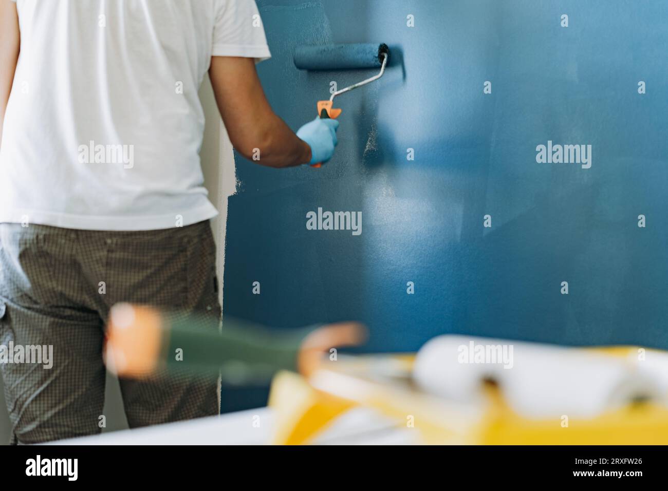 caucasian bearded man painting wall with paint roller. Painting ...