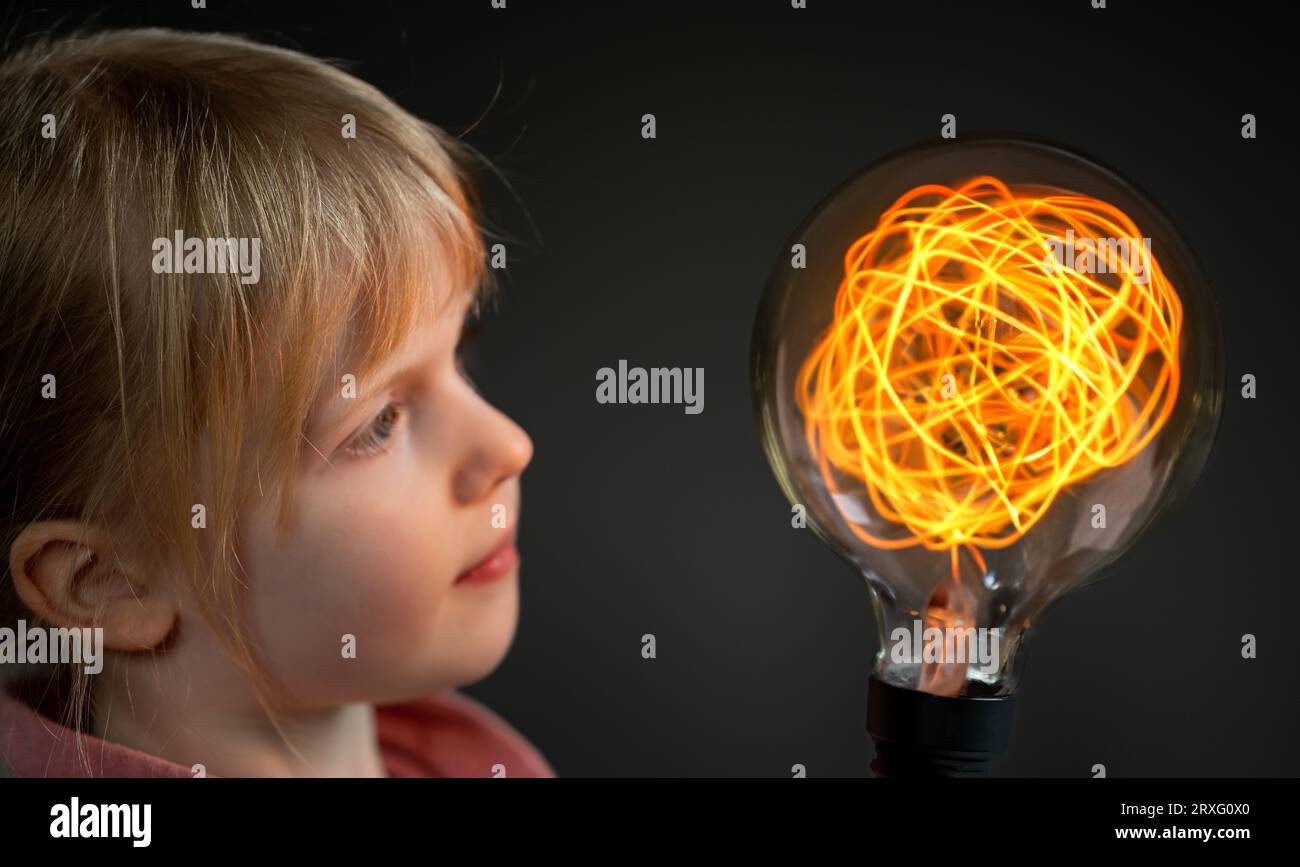 Girl looks at a atom model. Symbol for kids being curios about physics ...