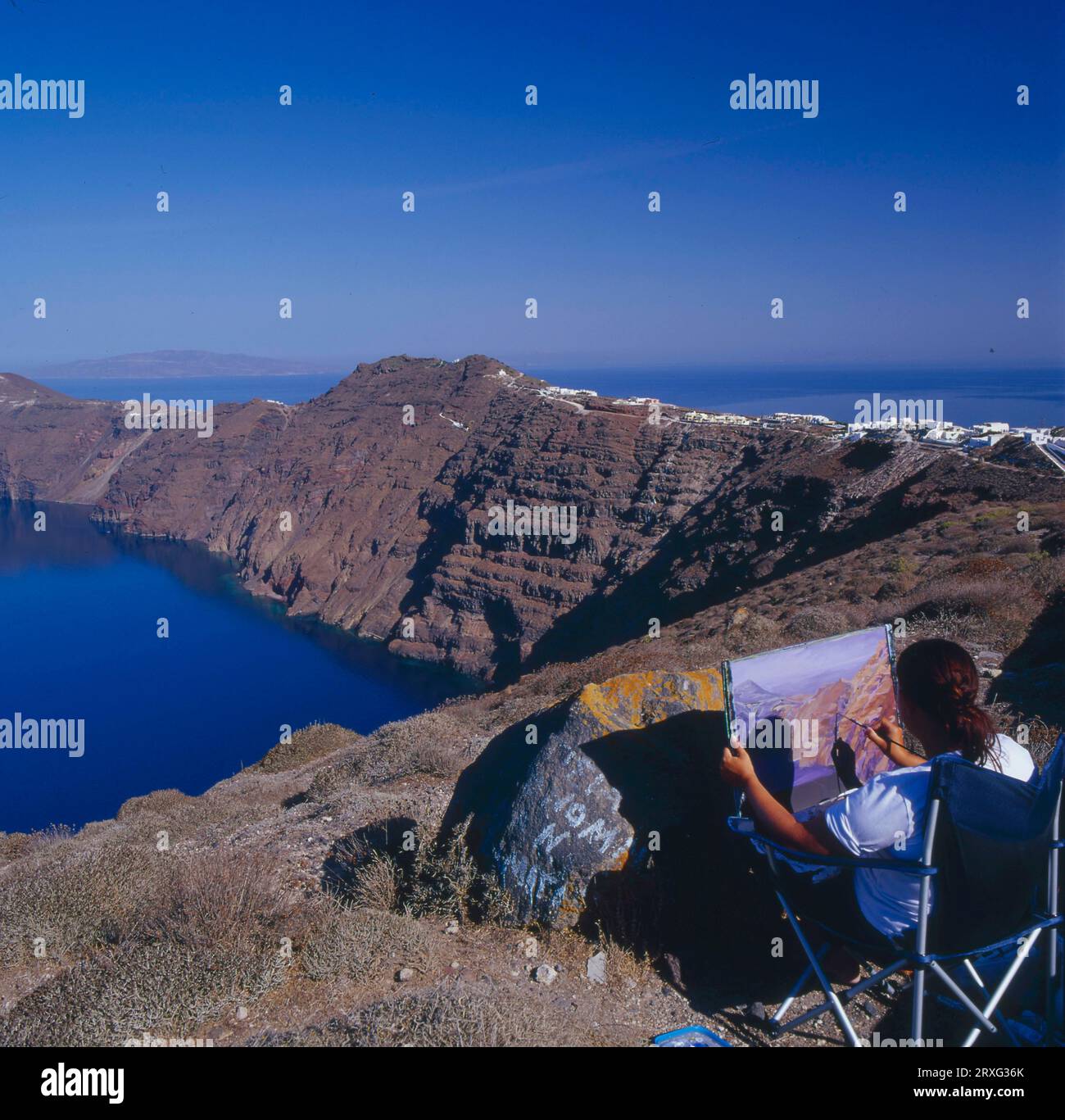 Painter at the crater rim between Thira (Fira) and Oia (la), below the ...