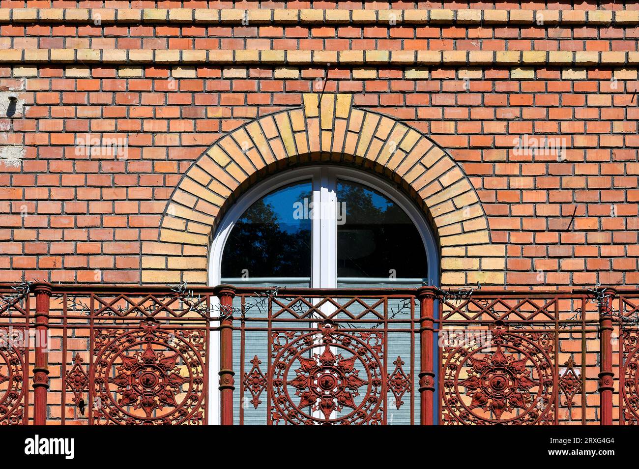 Clinker facade with arched window and richly decorated balcony railing ...