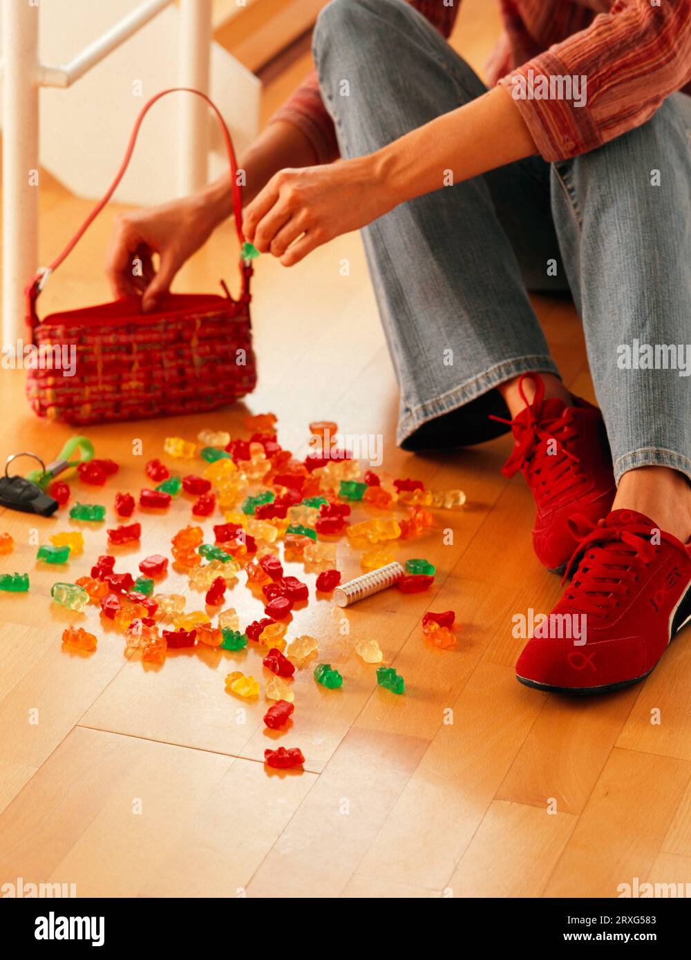 Lady sitting on the floor collecting lost gummy bears Stock Photo - Alamy