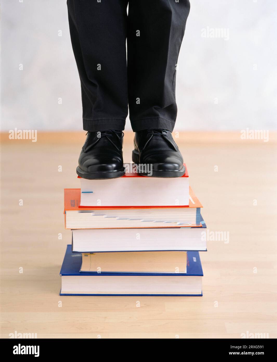 MaNN STANDS UP on pile of books man on a file of books Stock Photo - Alamy