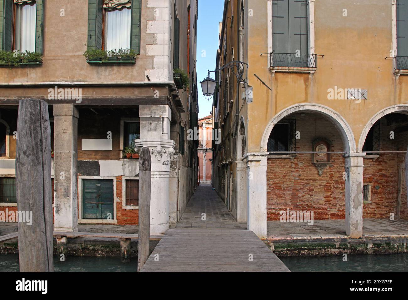 Wooden Pier and Narrow Passage Between Houses in Venice Italy Stock ...