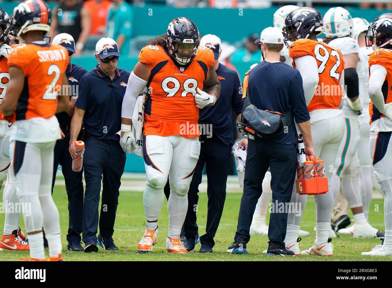Denver Broncos defensive tackle Mike Purcell (98) is helped back to the ...
