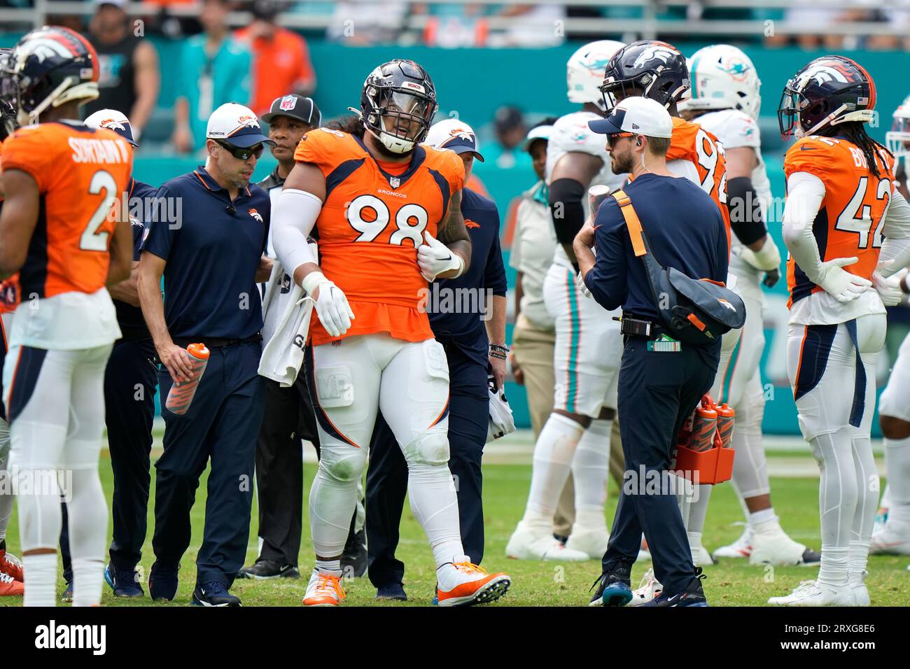 Denver Broncos defensive tackle Mike Purcell (98) is helped back to the ...