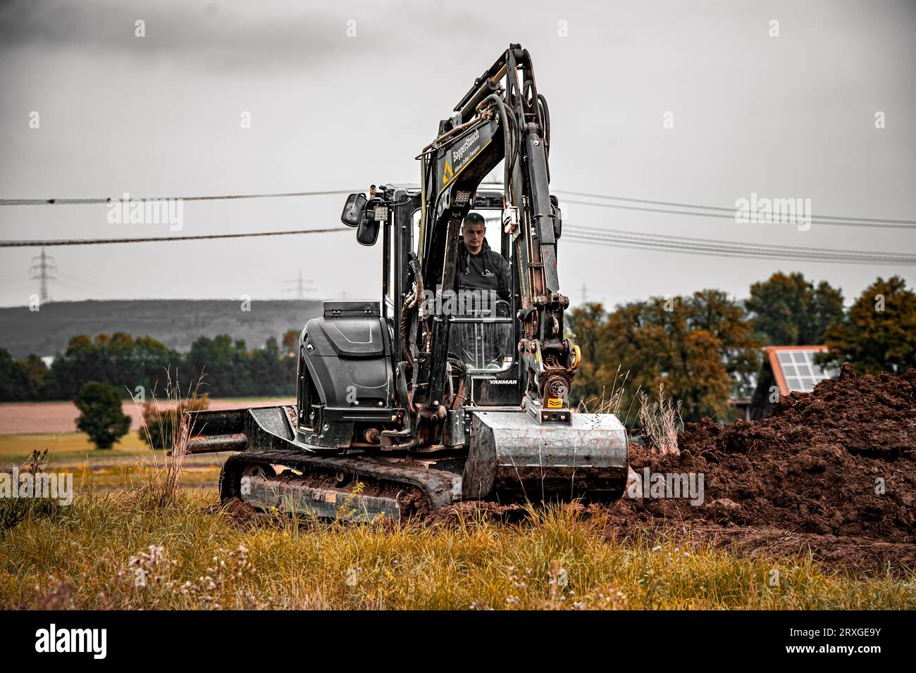 Black Yanmar mini tracked excavator during earthworks for house ...