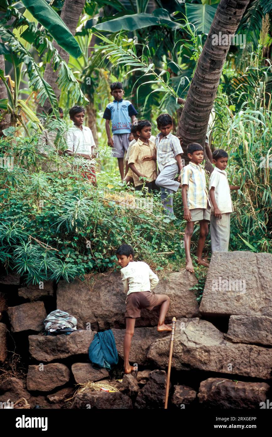 Boys enjoying their holidays standing near a river at Courtalam ...