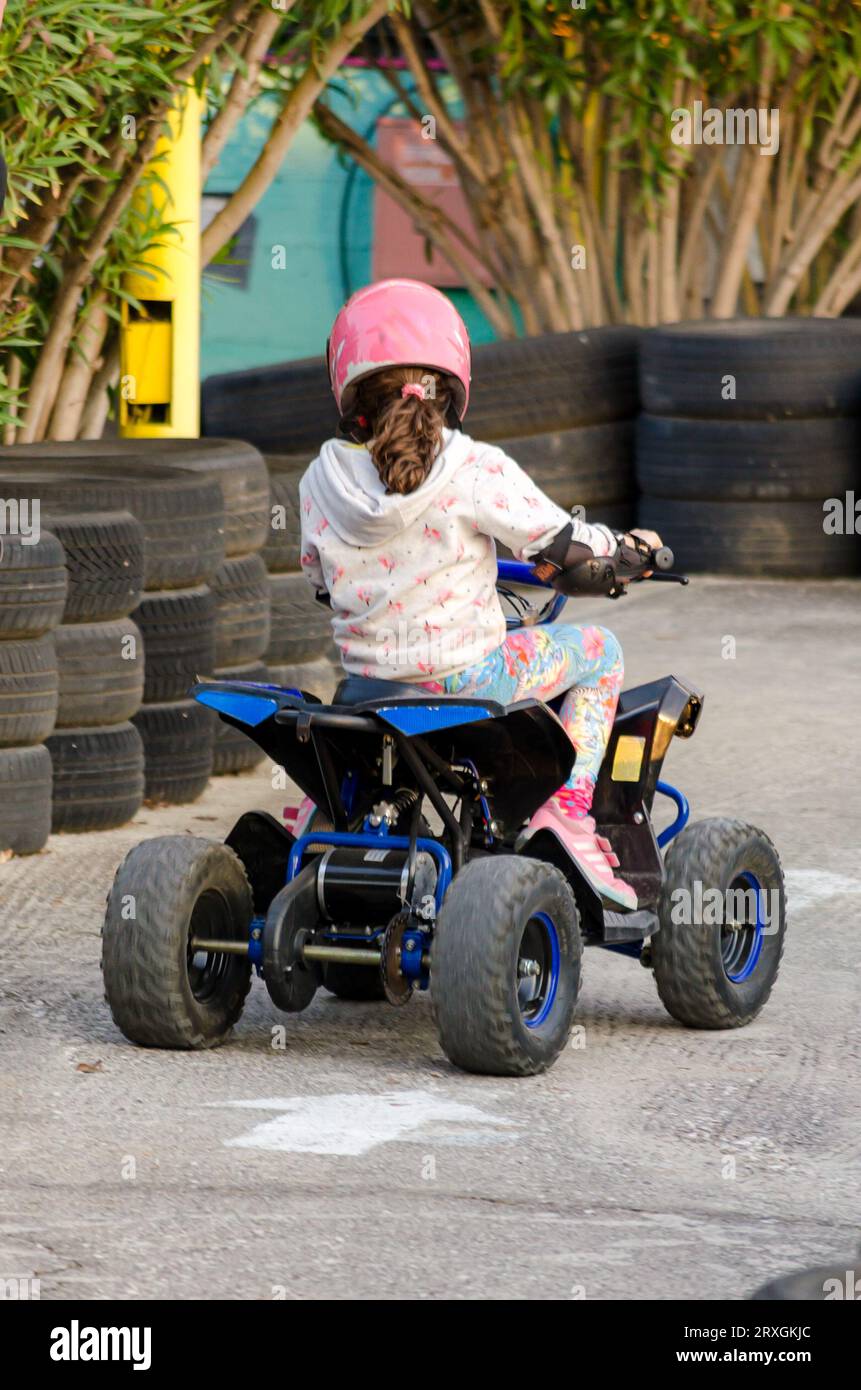 Little Girl Rides a Motorcycle ATV with Four Wheels. Outdoor Activity ...