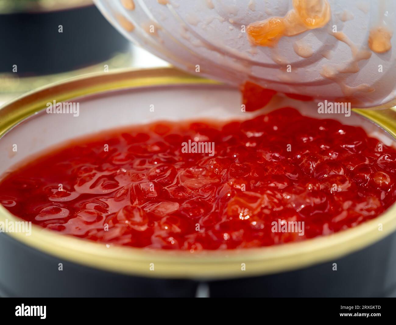 Open tin can with red caviar on a white background. Red caviar close-up ...