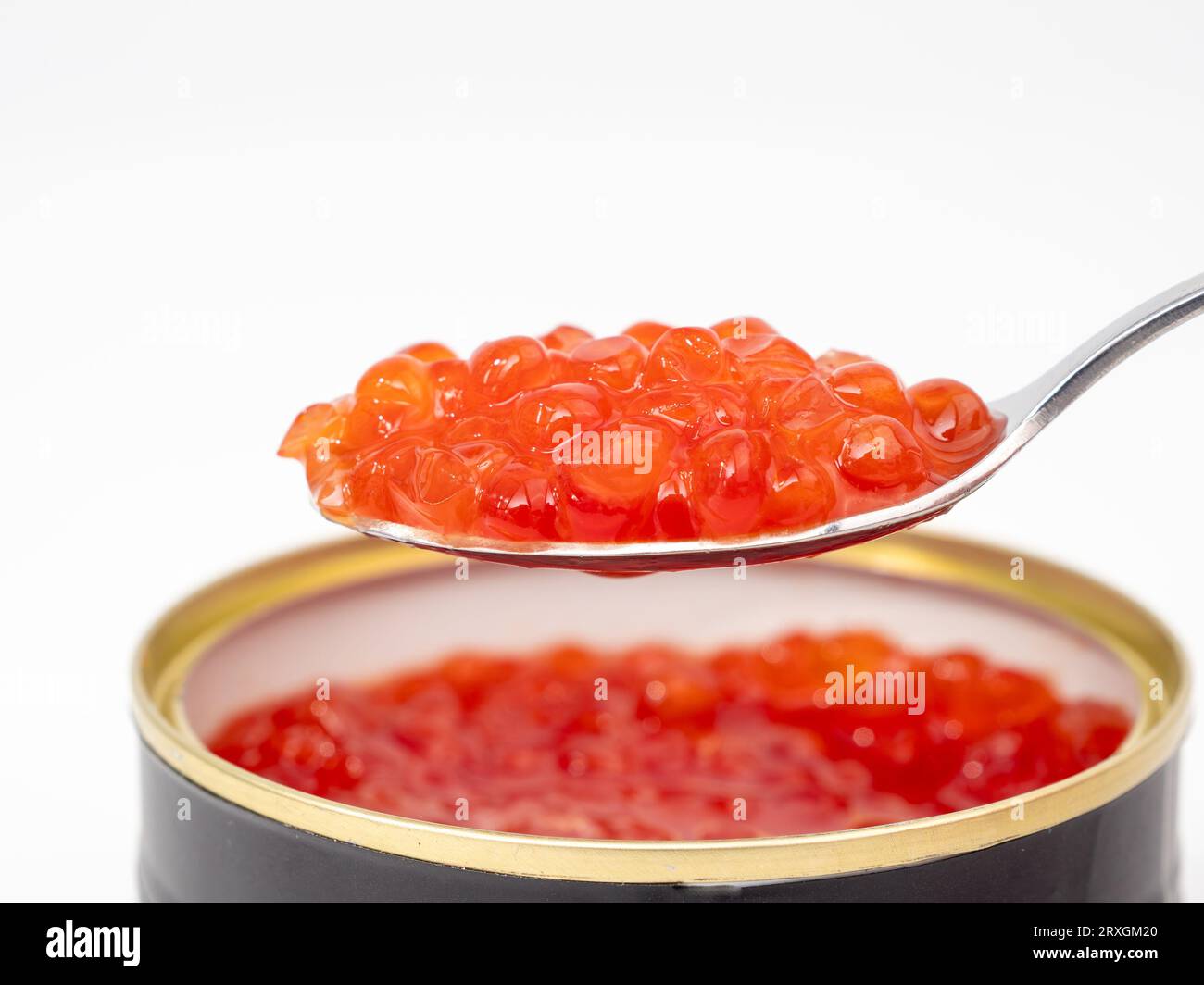 Open tin can with red caviar and a spoon on a white background. Red ...