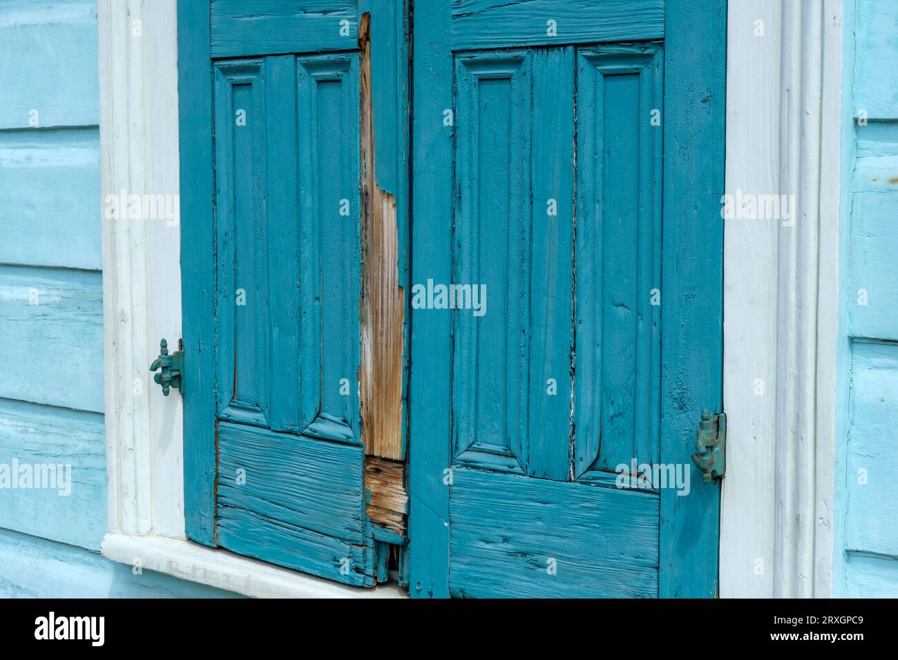 Closeup of antique, cracked and broken blue shutters that need repair ...