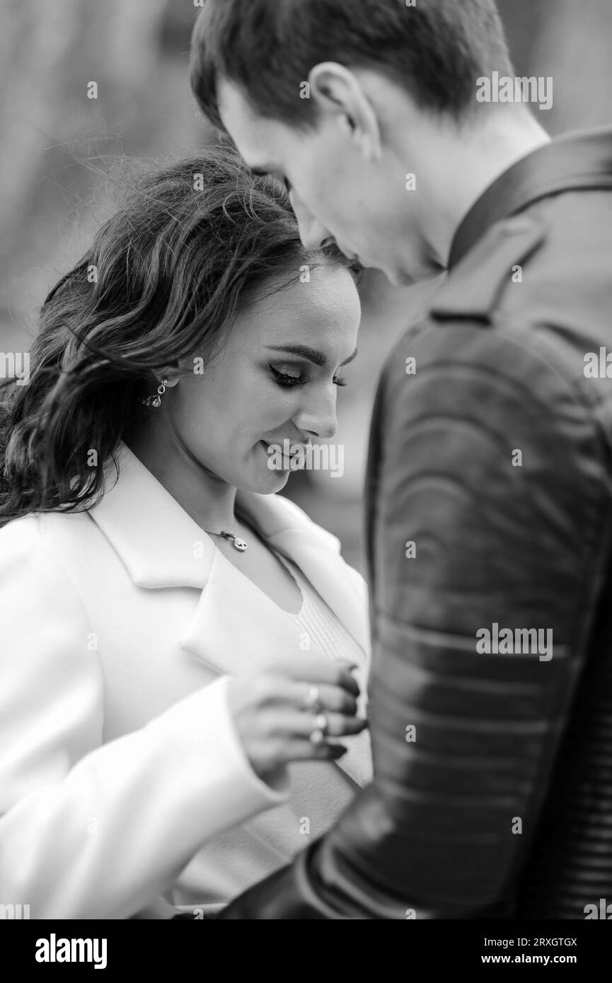A man hugs his pregnant wife. A man in a black jacket hugs and kisses a ...