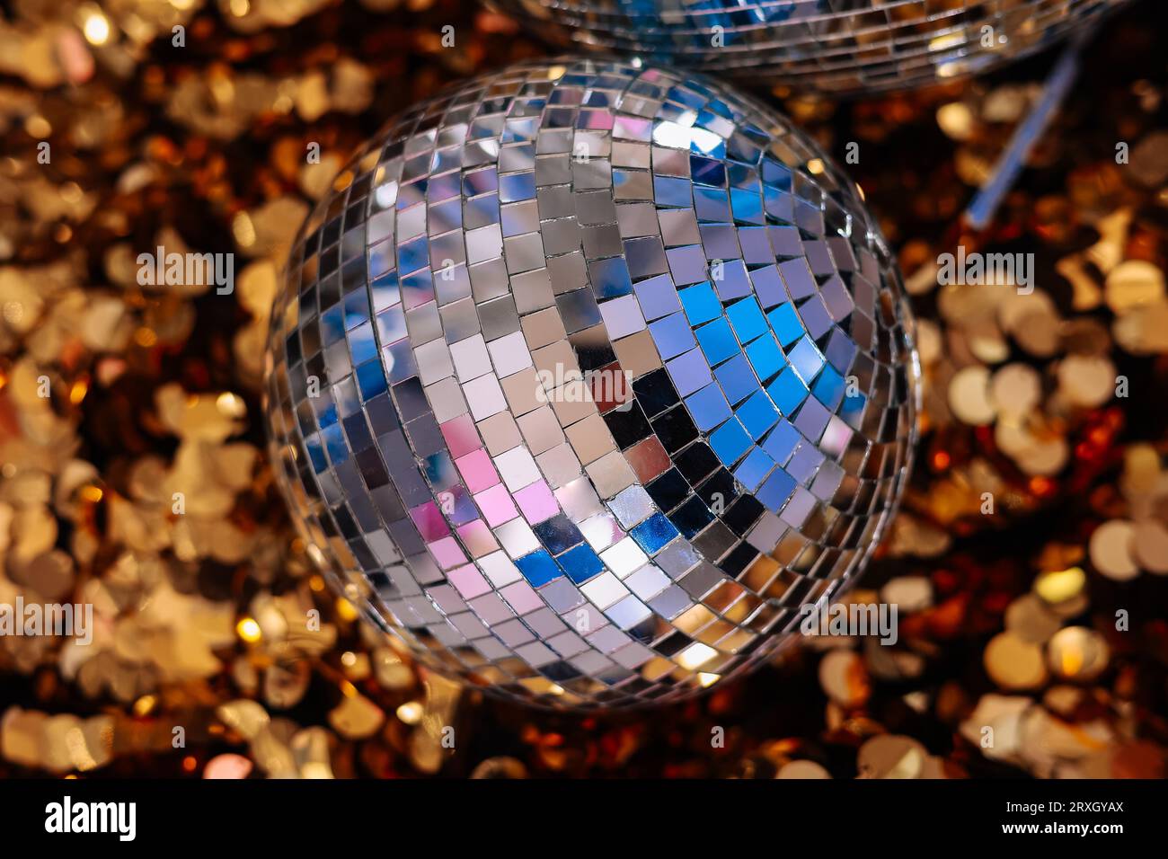 Bright silver glowing mirror disco balls on gold confetti background ...
