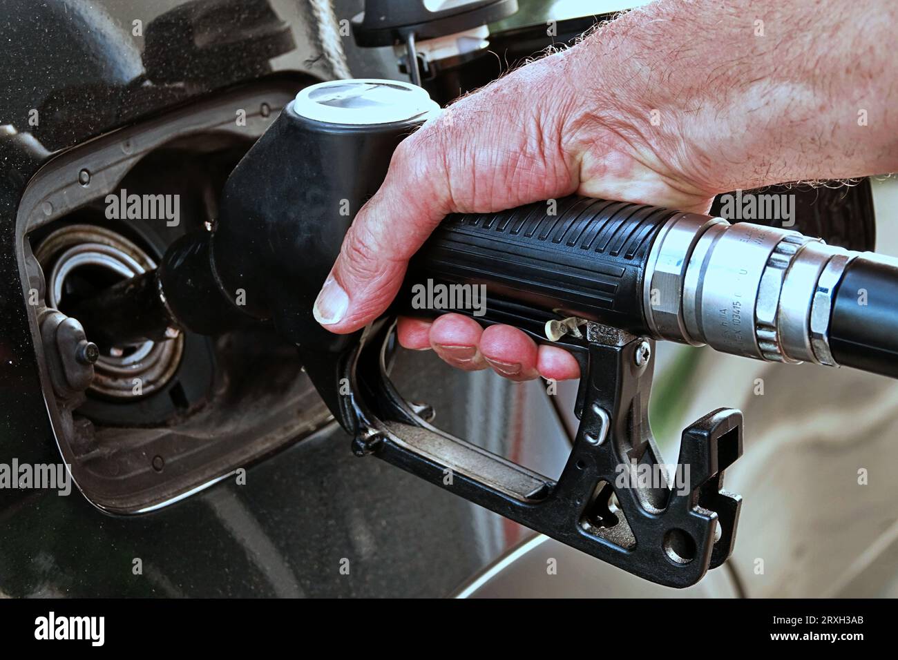 Refueling the car, a man's hand refills diesel fuel at the gas station ...