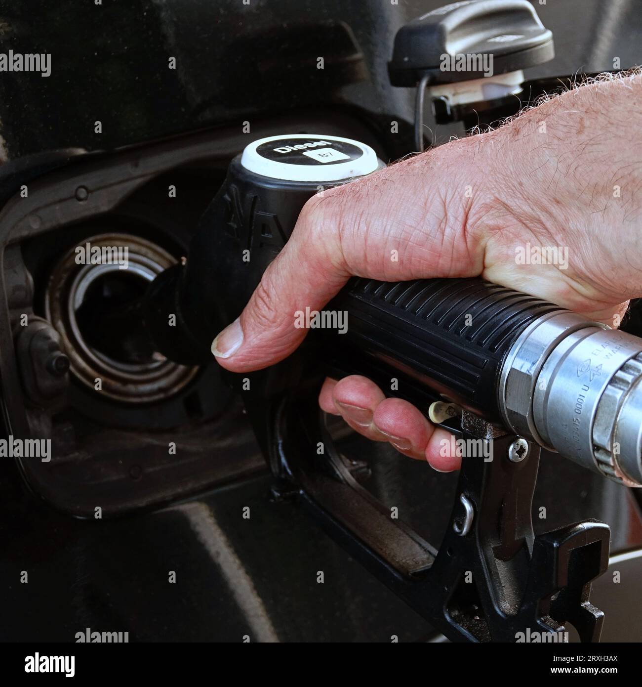 Refueling the car, a man's hand refills diesel fuel at the gas station ...