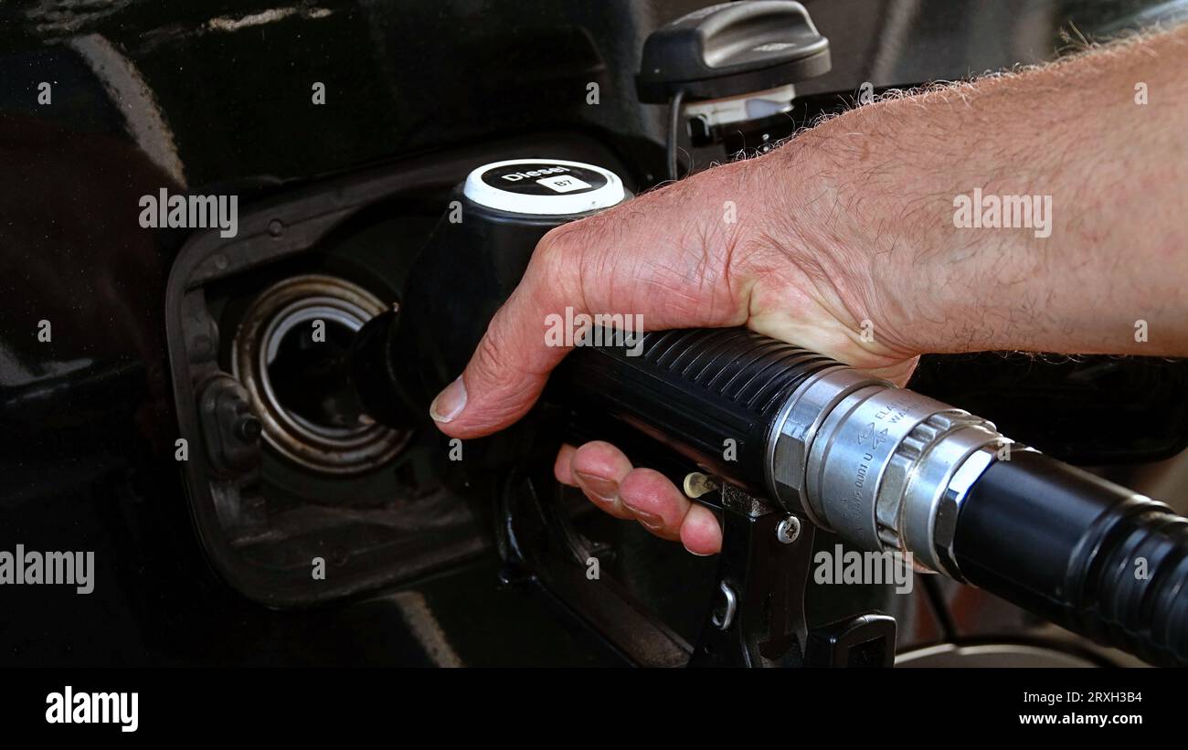 Refueling the car, a man's hand refills diesel fuel at the gas station ...