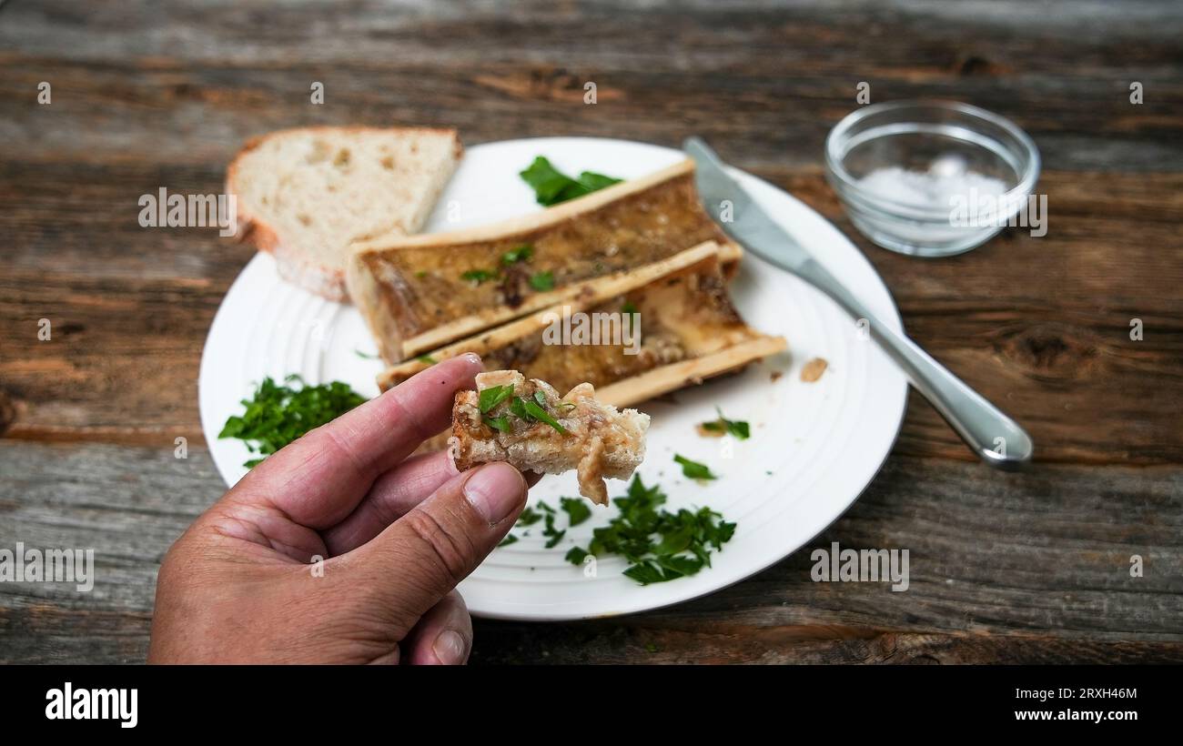 Hand hold bread with roasted marrow bones fat Stock Photo - Alamy