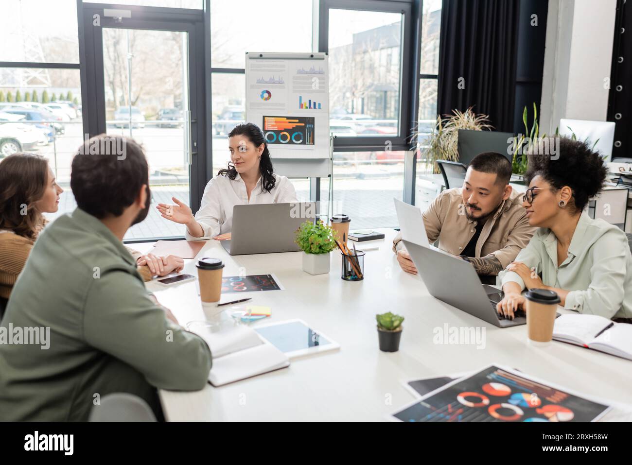 team leader talking to interracial business people during meeting in ...