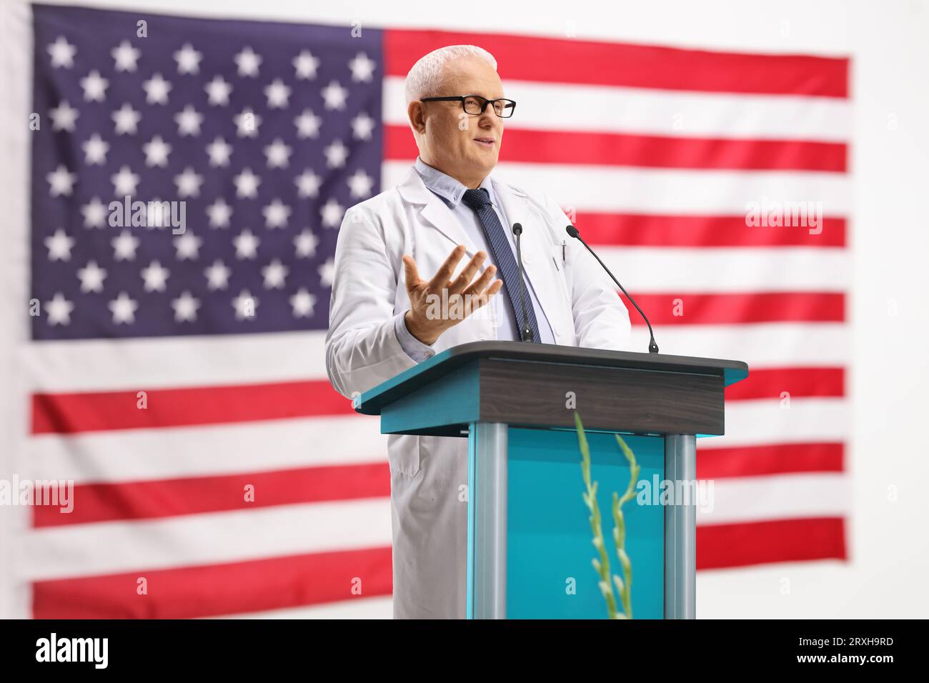 Mature doctor giving a speech at a conference on a podium in the USA ...