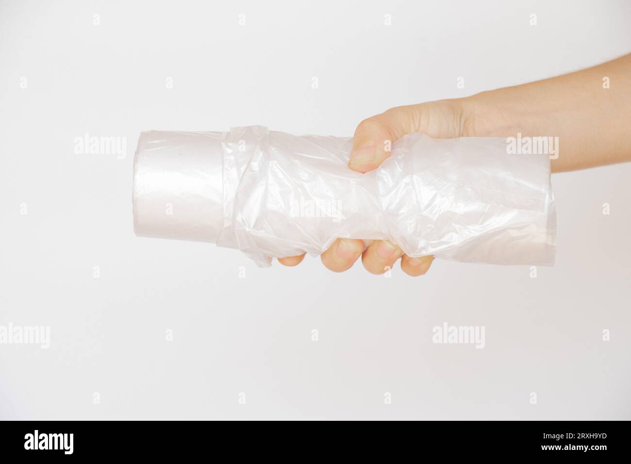 Female hands hold a roll of disposable plastic bags on a white ...