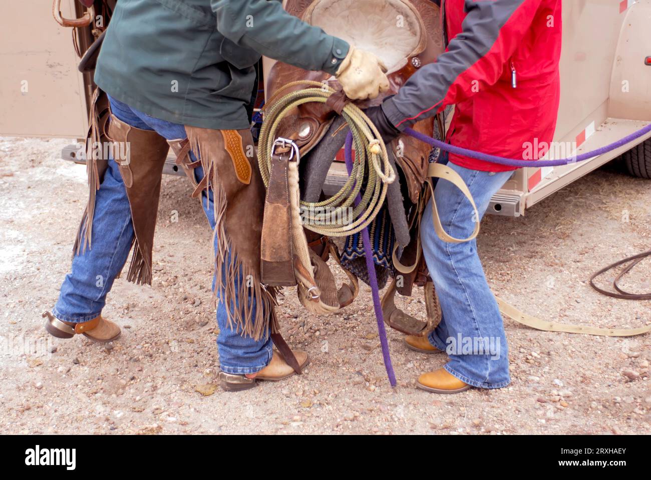 Ranch couple work together to lift a saddle into a trailer; Halsey ...