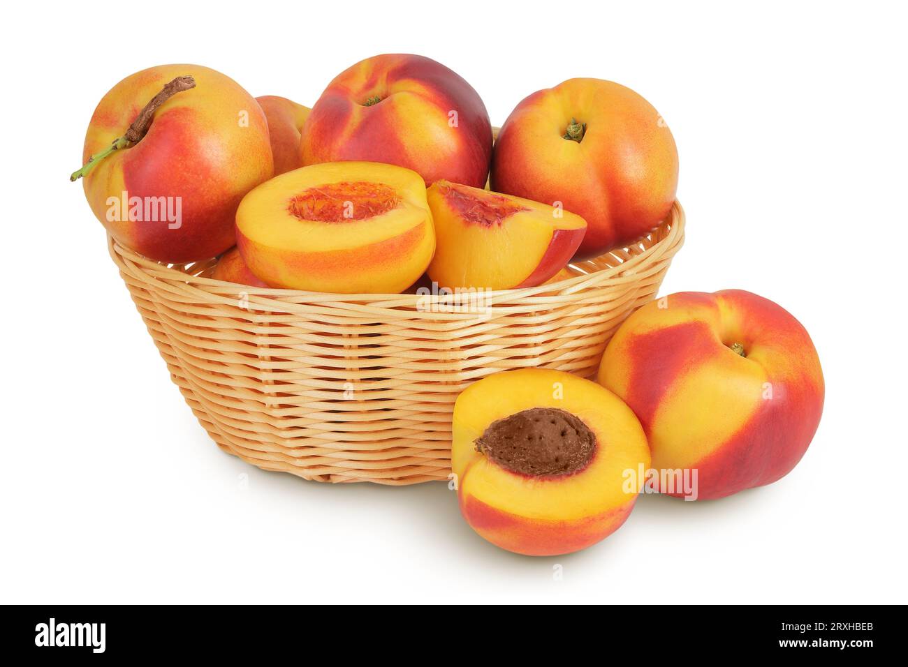 Ripe nectarine fruit with half in a wicker basket isolated on white ...