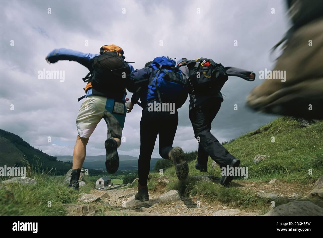 Participants of the Three Peaks Challenge race along a stone path; Ben ...