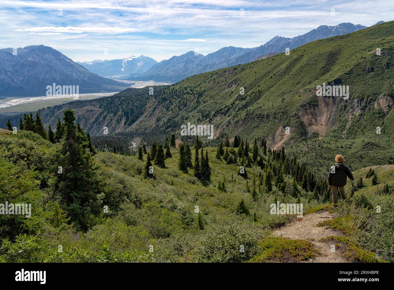 Person standing on a mountainside during a hike in the Yukon wilderness ...