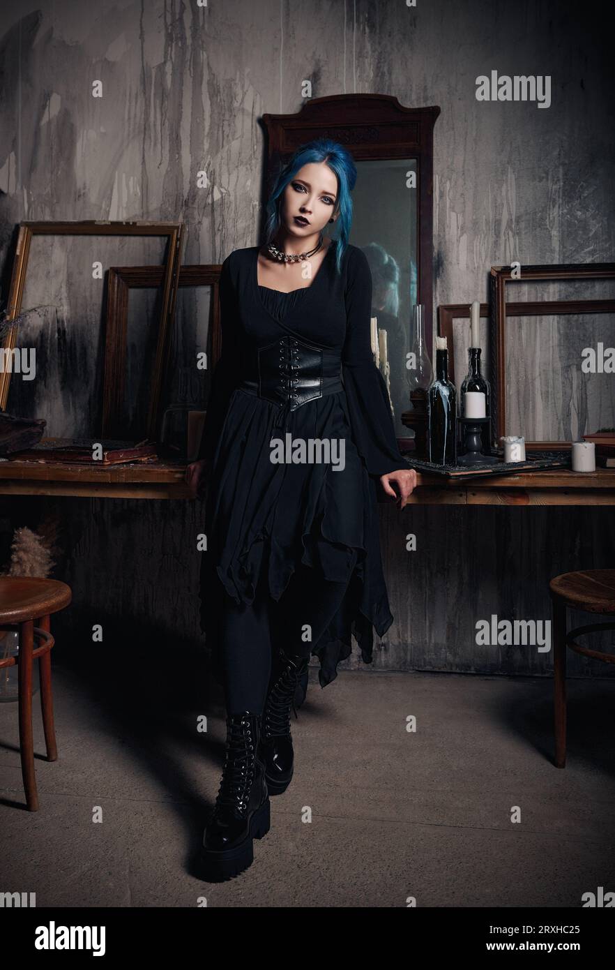 Indoors portrait of lovely goth girl in black dress. Blue-haired gothic ...