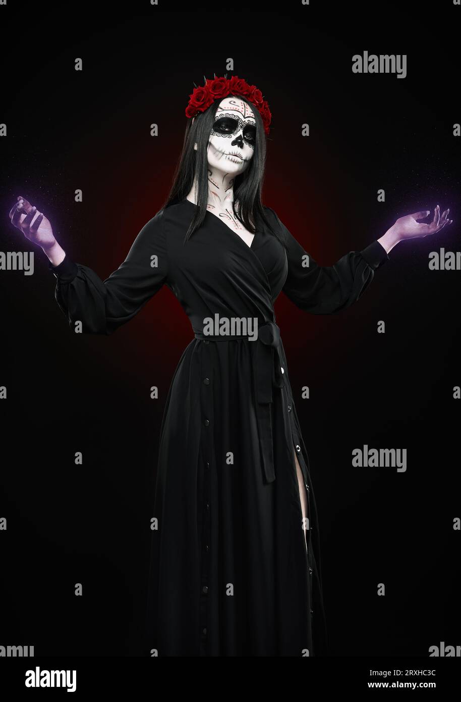 Young woman with calavera (sugar skull) makeup casts the spell. The ...